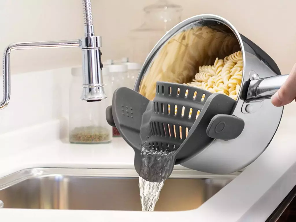 Bydd yr atodiad colander silicon hwn yn gwneud straenio pasta yn awel - a dim ond $12 ar Amazon.