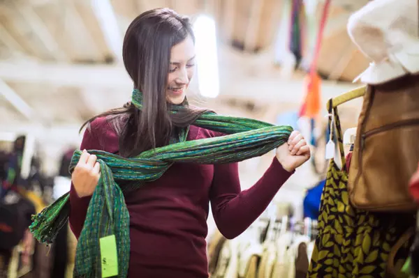 Mujer de compras en la tienda de segunda mano