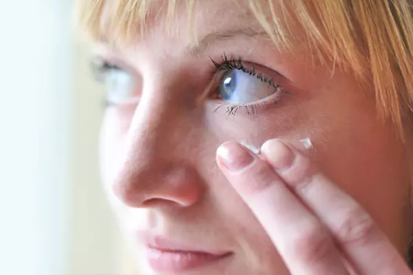 Vrouw die lotion aanbrengt