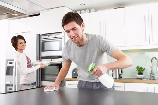 Pareja joven trabajando juntos para limpiar su cocina