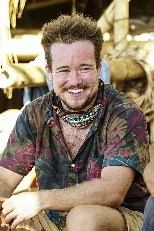 Zeke Smith tersenyum di perkemahan di Survivor: Millennials Vs. Gen-X