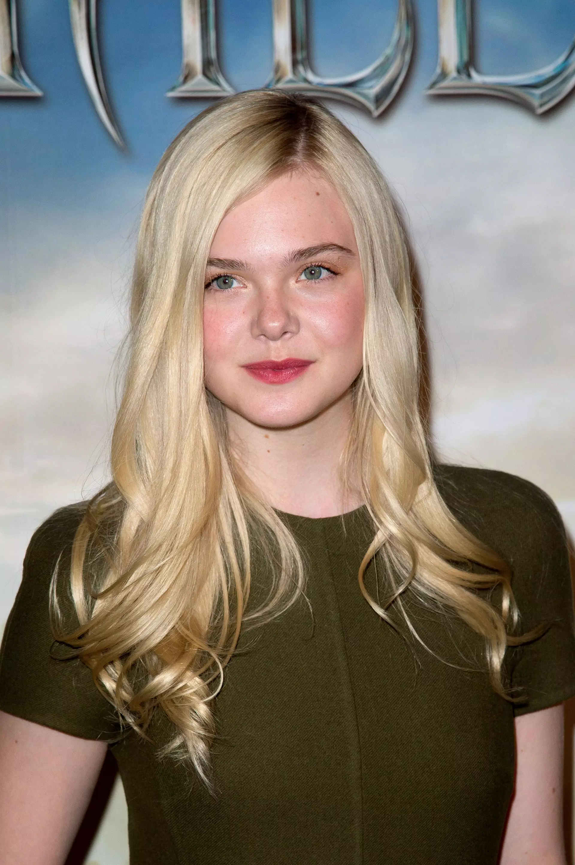 Η Elle Fanning στο φωτογραφικό κάλεσμα Maleficent φορώντας ένα fit και flare πράσινο φόρεμα