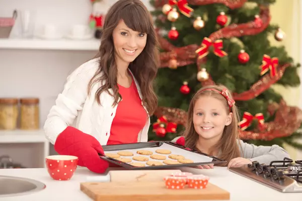 Ibu dan anak perempuan membuat biskut Krismas