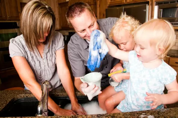 familia lavando pratos xuntos na cociña moderna