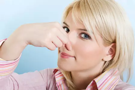 Žena drži nos