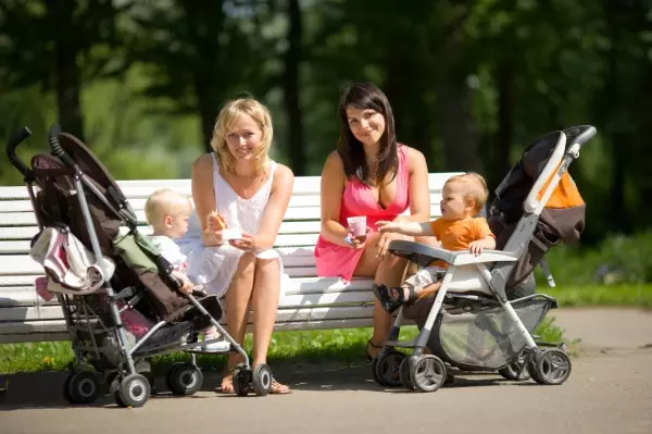 公园里快乐的妈妈们带着婴儿推车