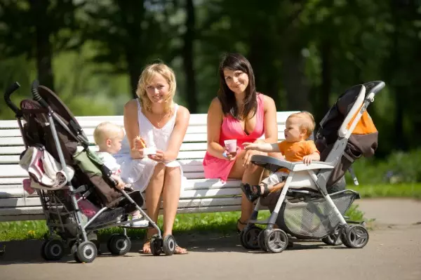 Masayang mga ina sa parke na may mga sanggol na naka-stroller