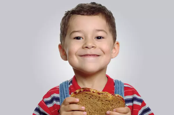 Bambino che mangia grano intero