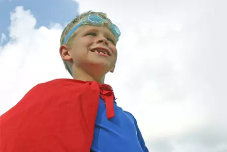 हॅलोविनसाठी सुपरमॅन म्हणून कपडे घातलेला मुलगा