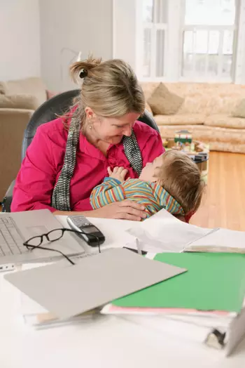 Mutter arbeitet von zu Hause aus mit Kleinkind