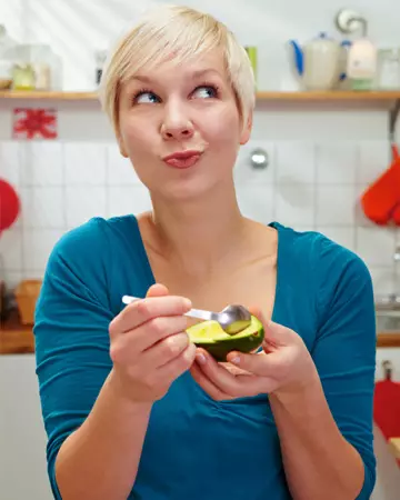 Vrouw die avocado eet