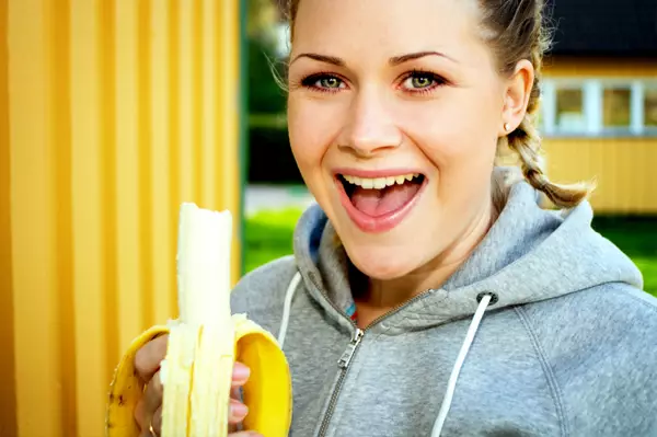 Kvinna som äter banan efter träning