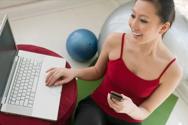 कंप्यूटर के पास व्यायाम करती महिला