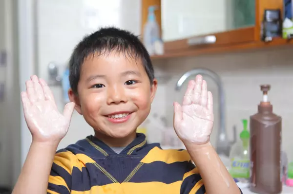 लहान मुलगा हात धुत आहे