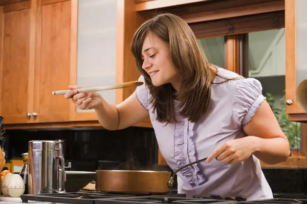 Mulher cozinhando na frigideira